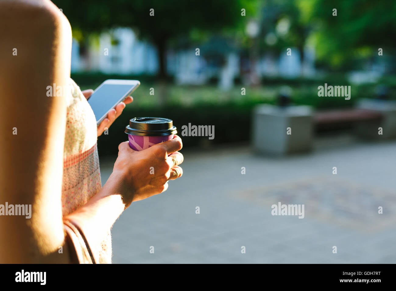 woman drinking coffee and looking at phone Stock Photo - Alamy