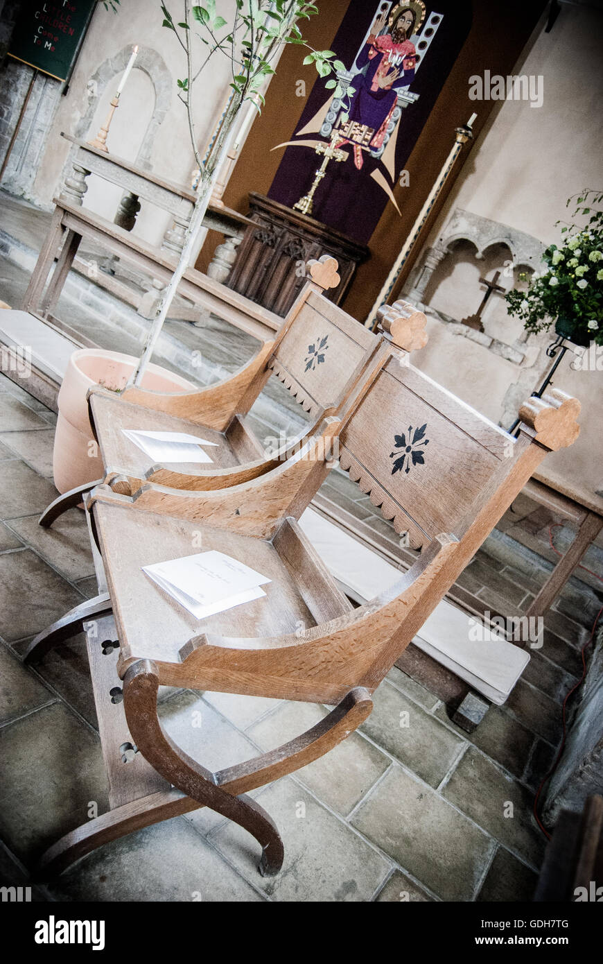 Bride and groom wooden carved wedding chairs in an old stone church ...