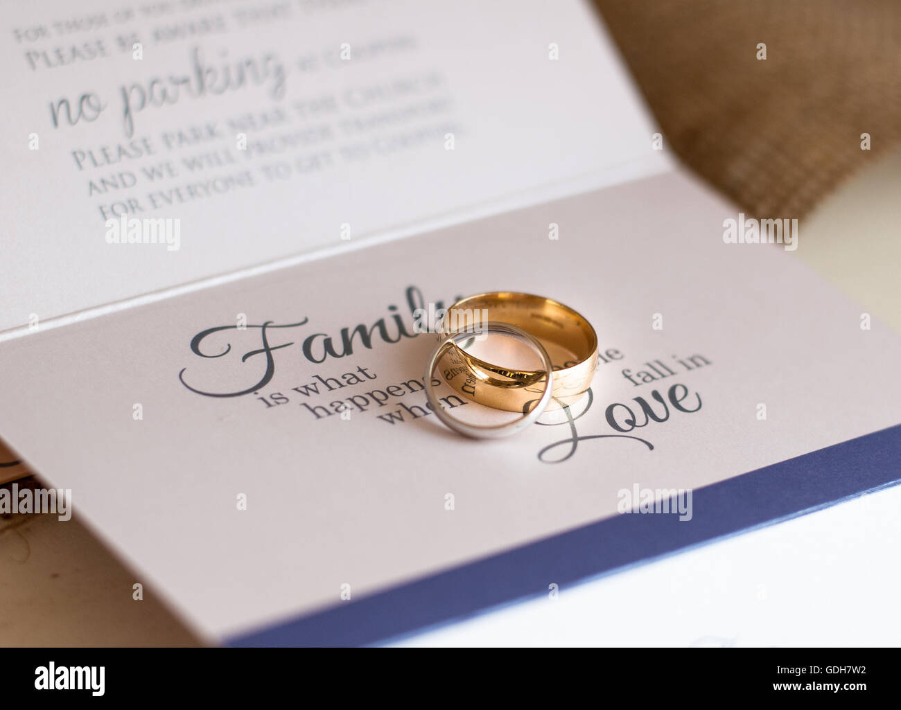 Wedding rings laying on a wedding invitation Stock Photo - Alamy