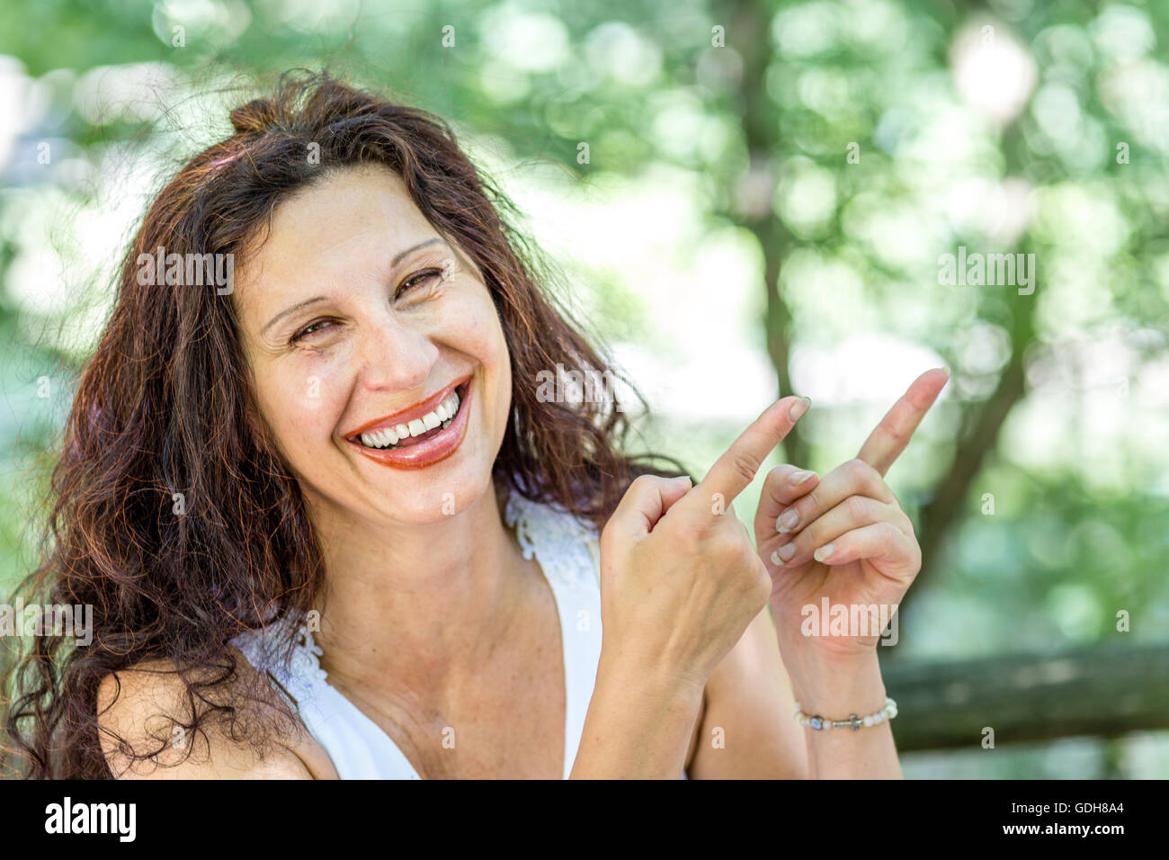 happy attractive woman pointing fingers away Stock Photo - Alamy