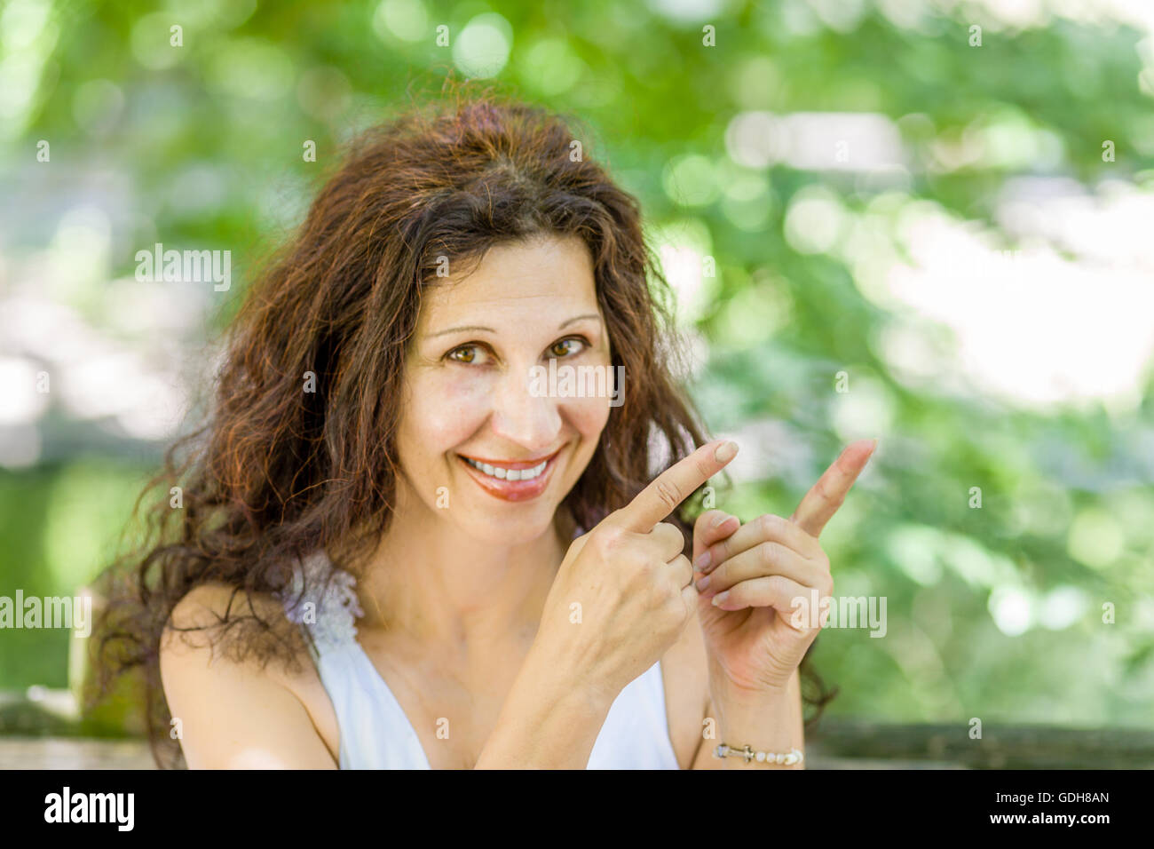 happy attractive woman pointing fingers away Stock Photo - Alamy