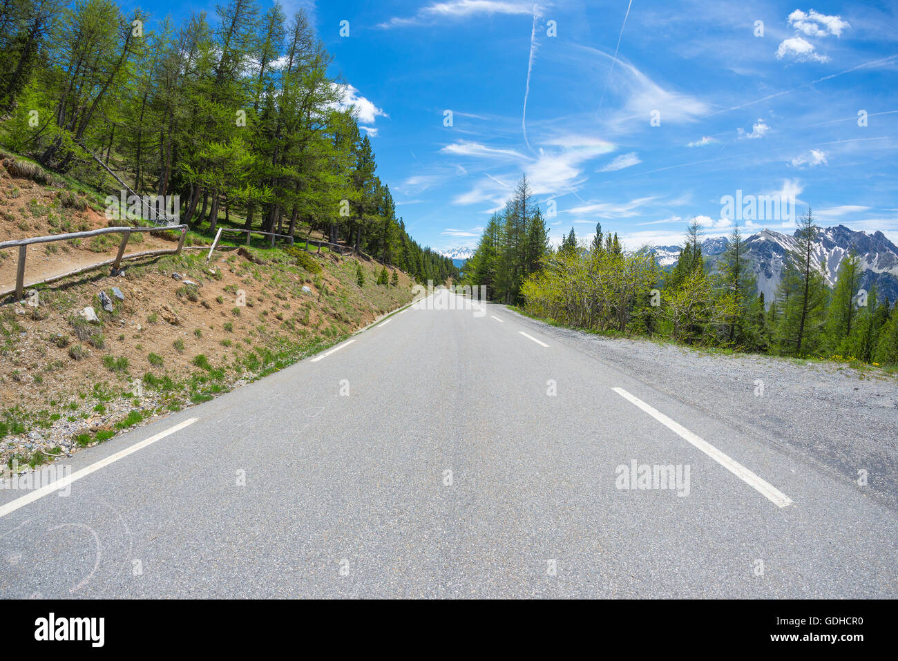Paved two lane road crossing mountains and forest in scenic alpine ...