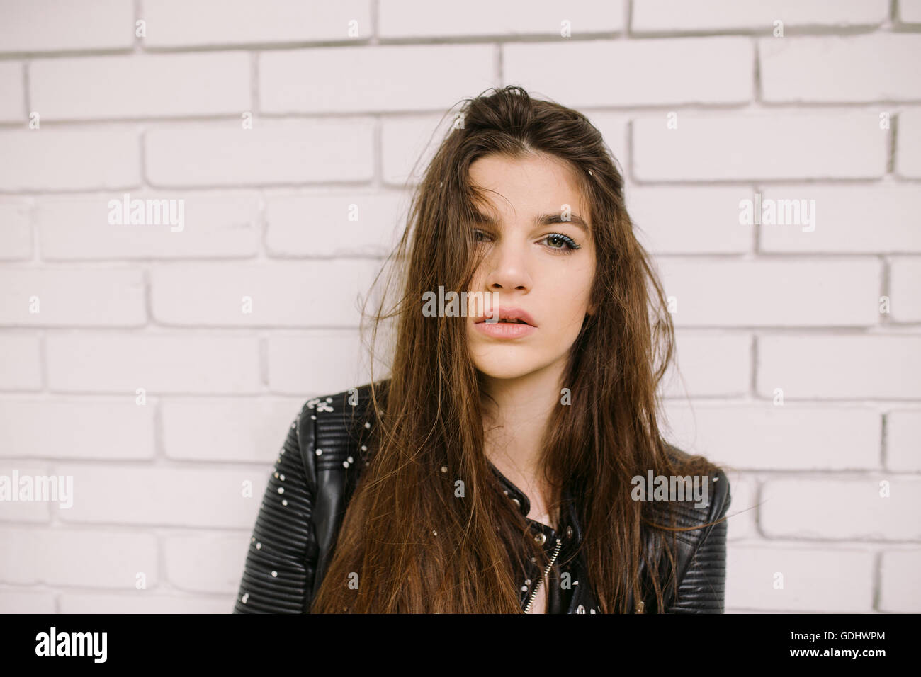 Portrait of a beautiful young woman leaning against the wall Stock ...