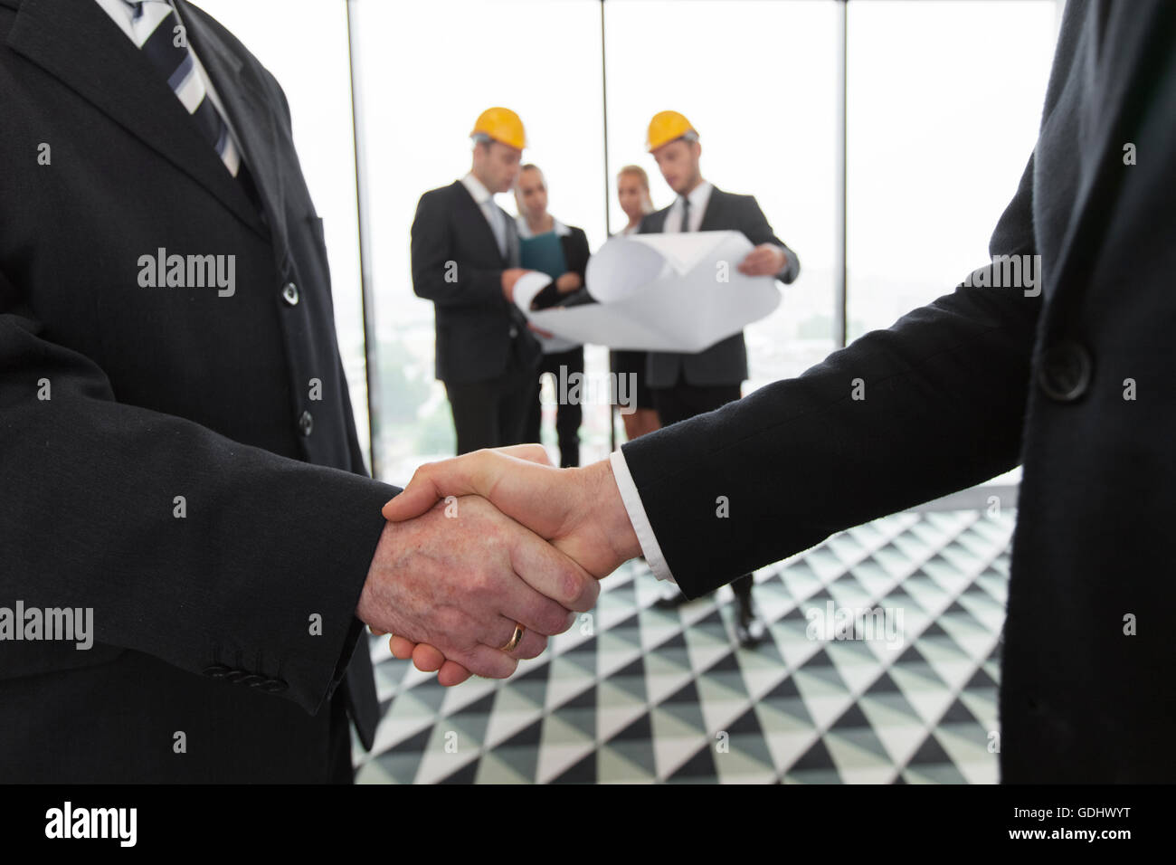 Handshake of architect and investor, business team with blueprint on ...