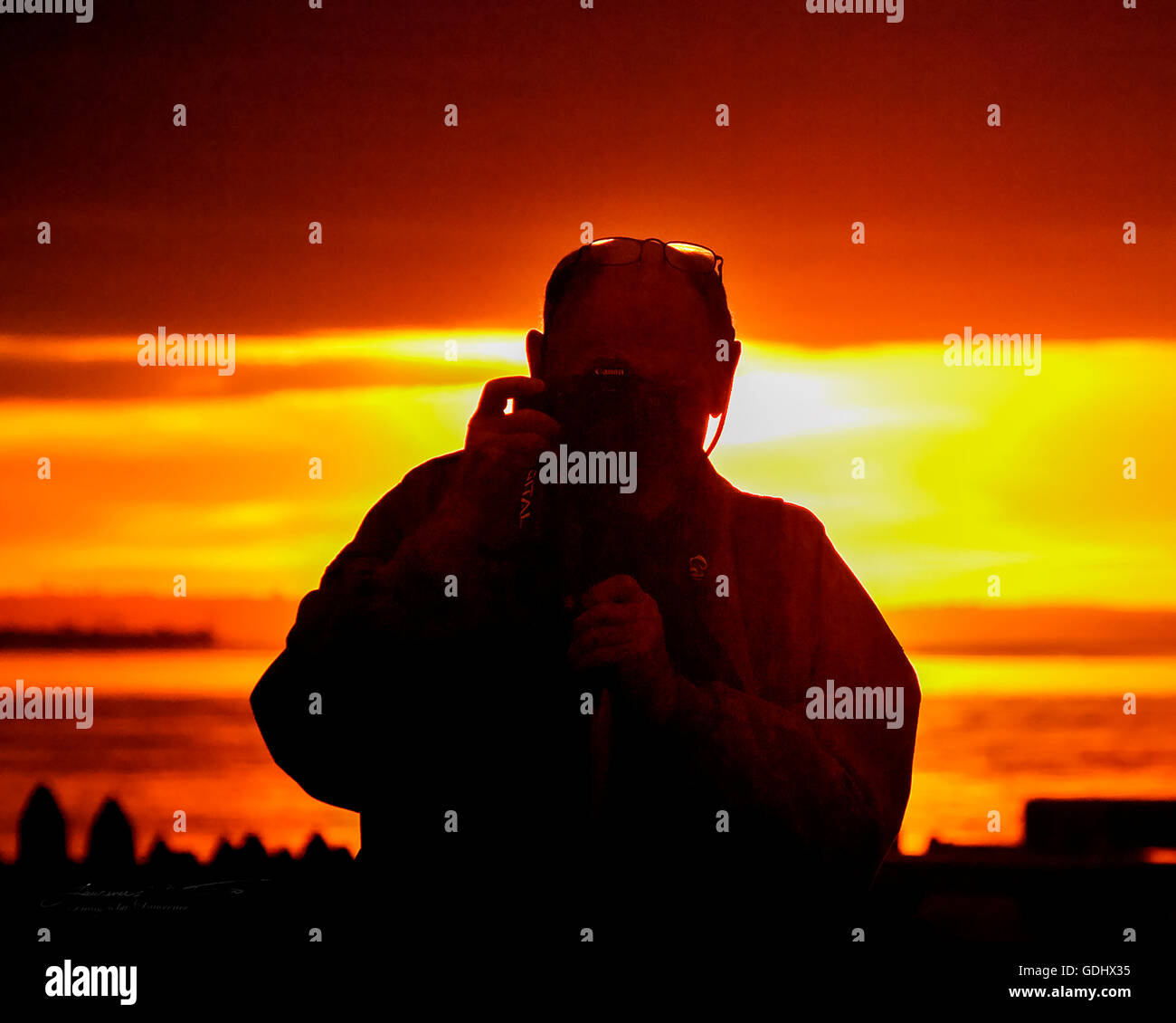 Photographer shooting a beautiful sunset Stock Photo - Alamy