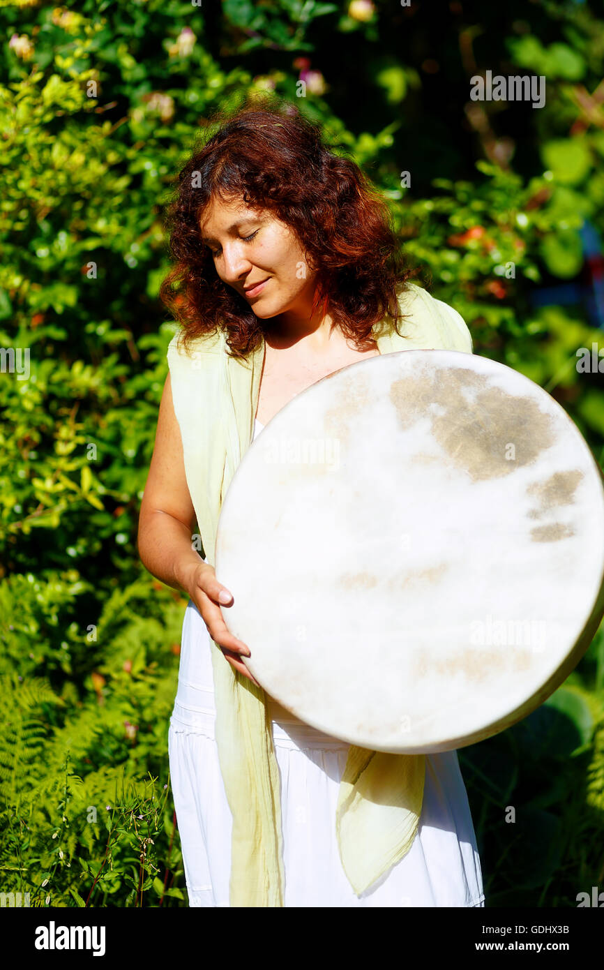 beautiful shamanic girl playing on shaman frame drum on background with ...