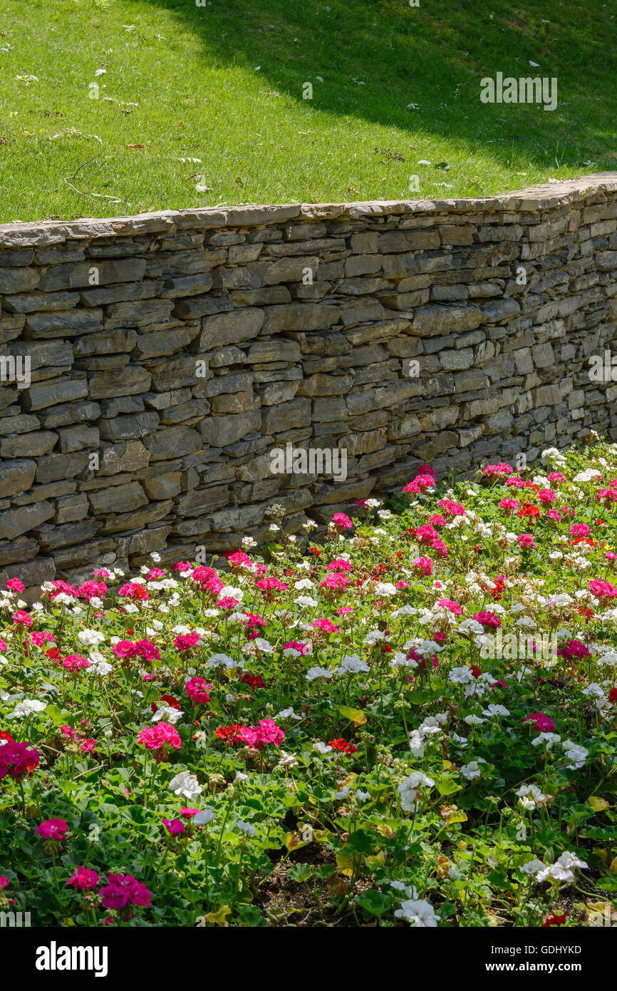 Flowers and retaining wall brick Stock Photo - Alamy