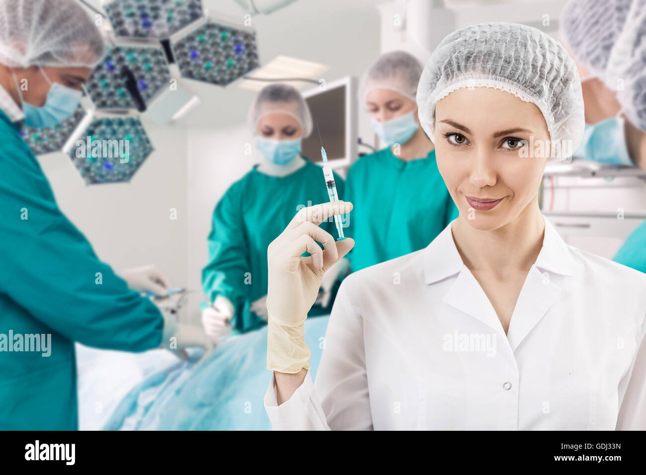 Young female anesthetist with syringe on the surgery teem background ...