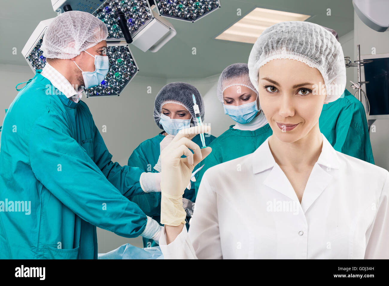 Young female anesthetist with syringe on the surgery teem background ...