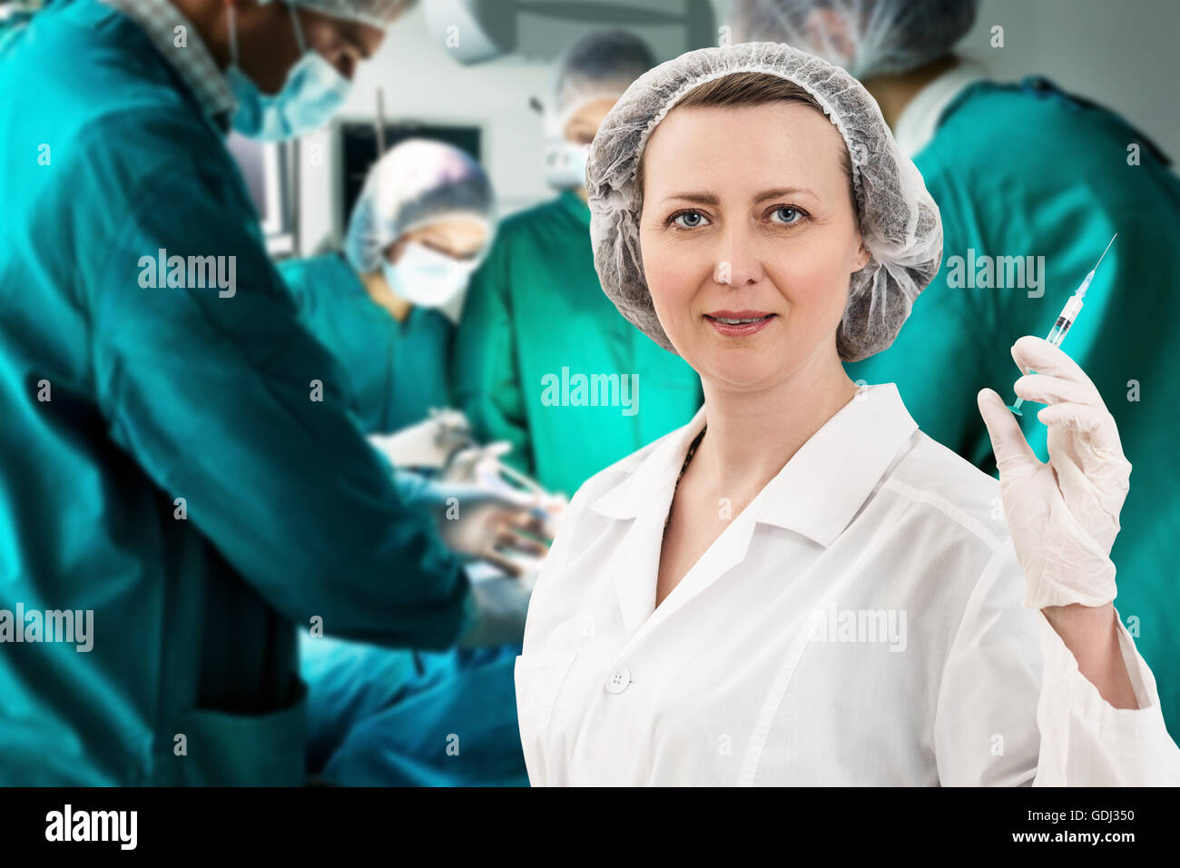 Adult female anesthetist with syringe on the surgery teem background ...