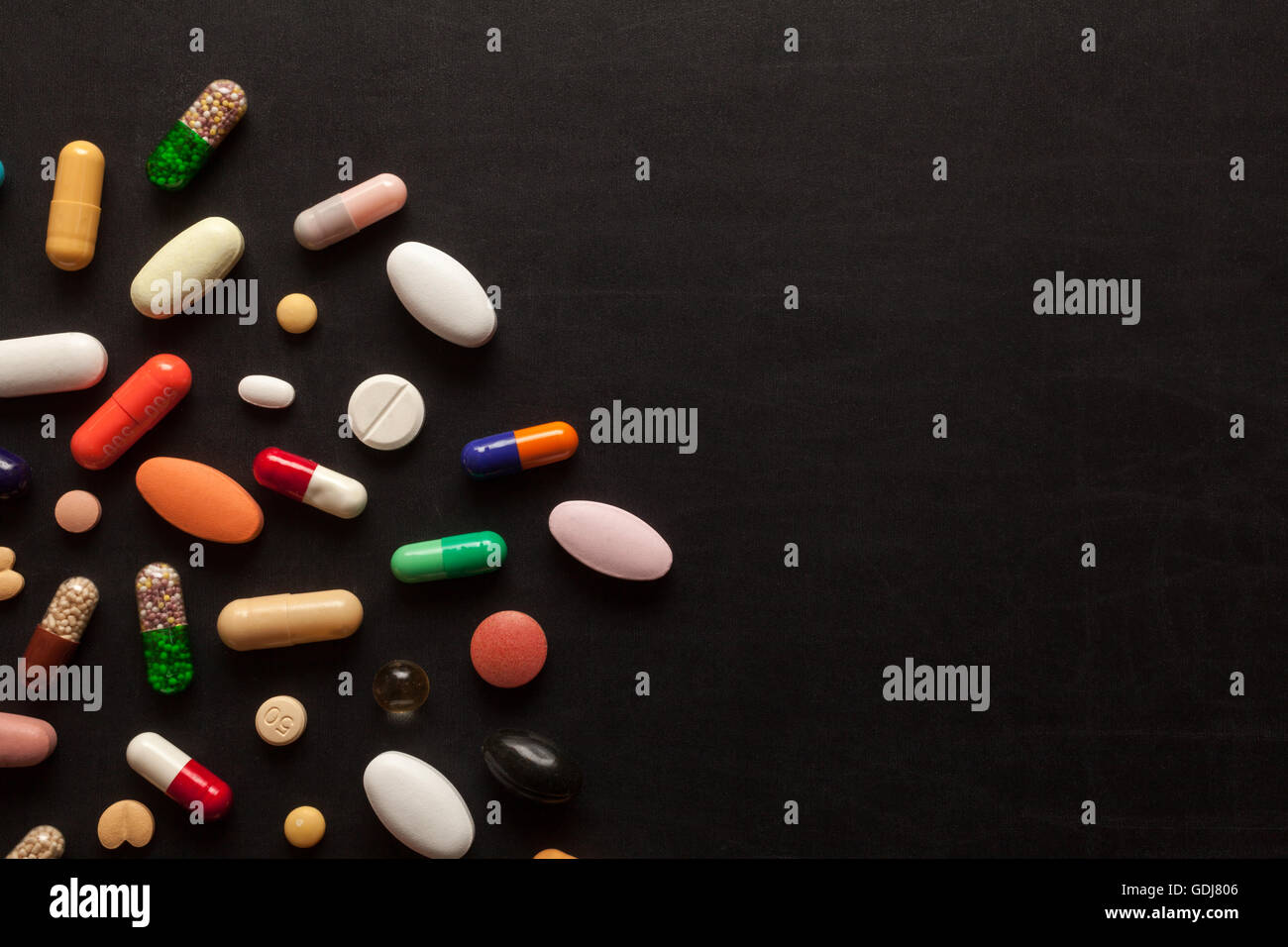 Colorful pills over dark background Stock Photo - Alamy