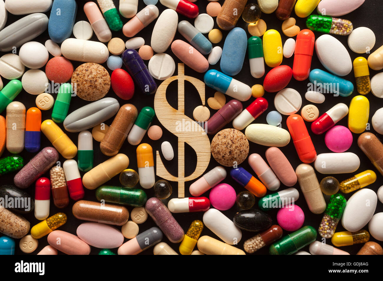 Wooden dollar sign surrounded by colorful pills Stock Photo - Alamy