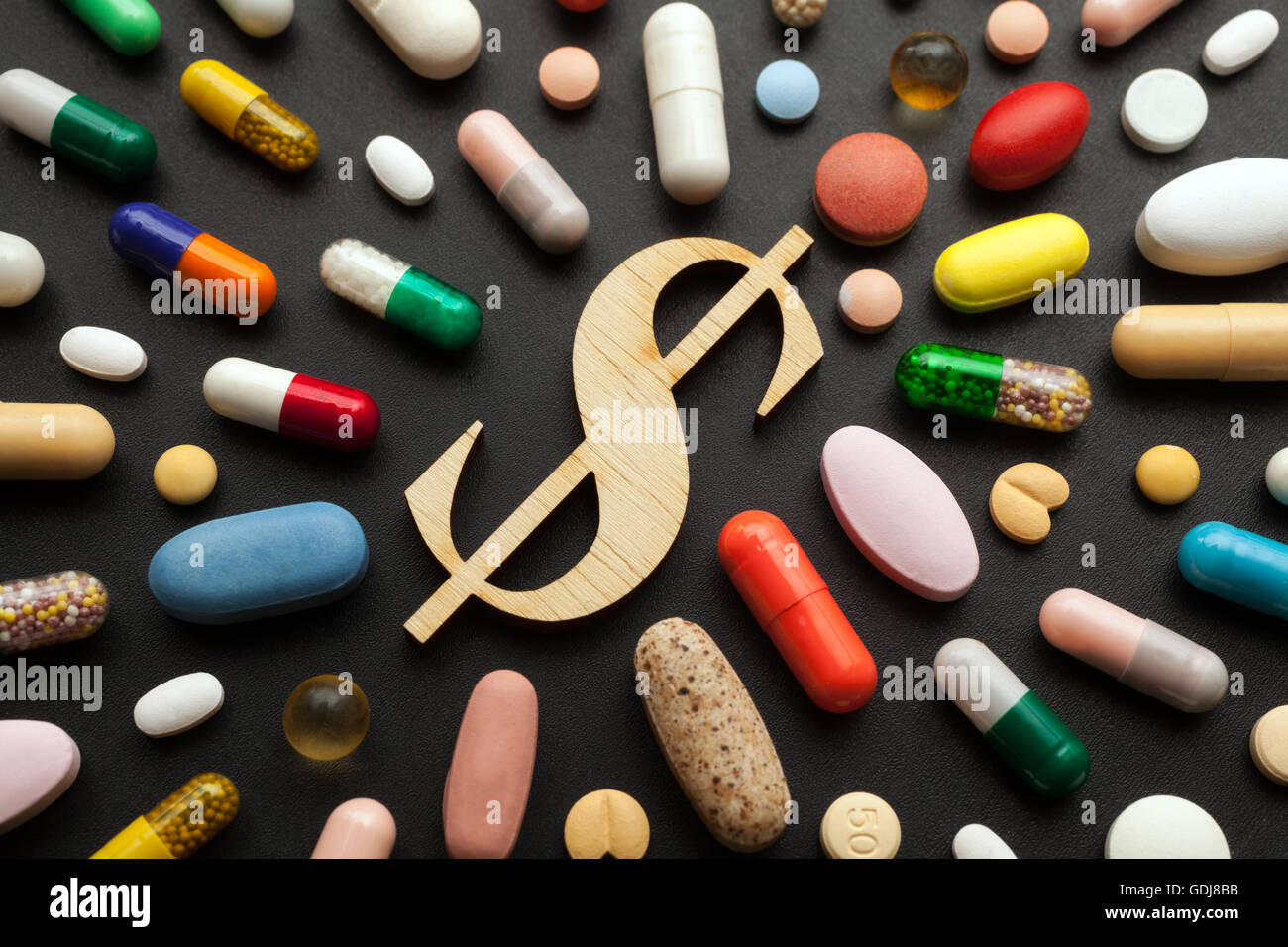 Wooden dollar sign surrounded by colorful pills Stock Photo - Alamy
