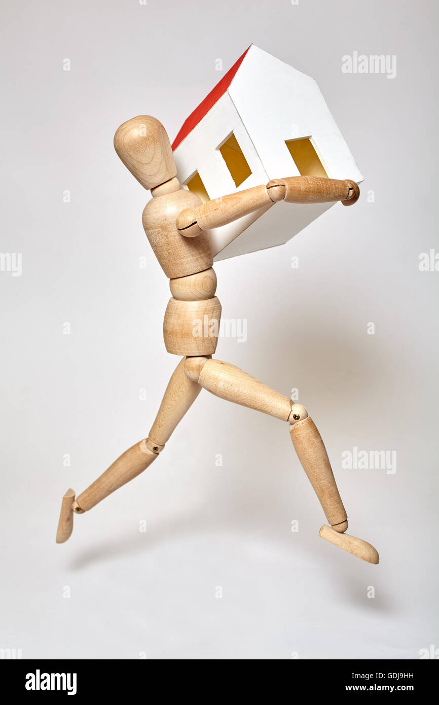Dummy carrying small house on white background Stock Photo - Alamy