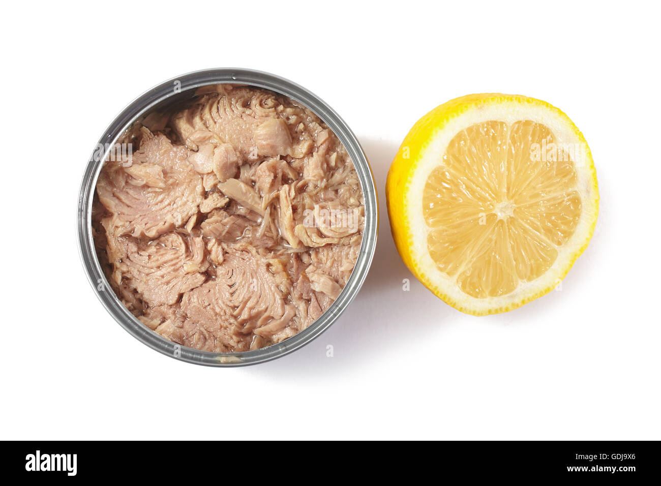 Open tuna tin with half lemon on a white background Stock Photo - Alamy