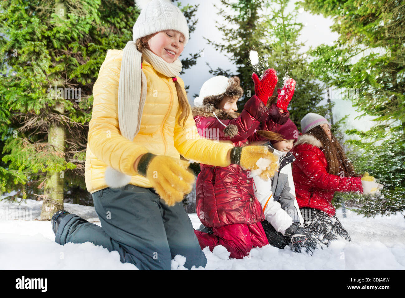 Smiling friends playing with snow in winter woods Stock Photo - Alamy