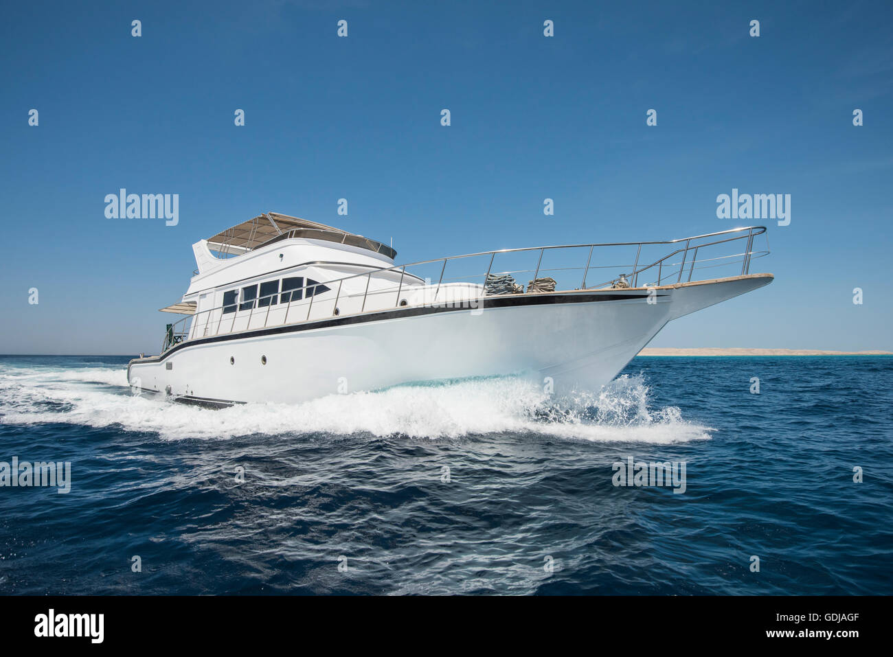 Luxury motor yacht boat sailing under way on tropical ocean with bow ...
