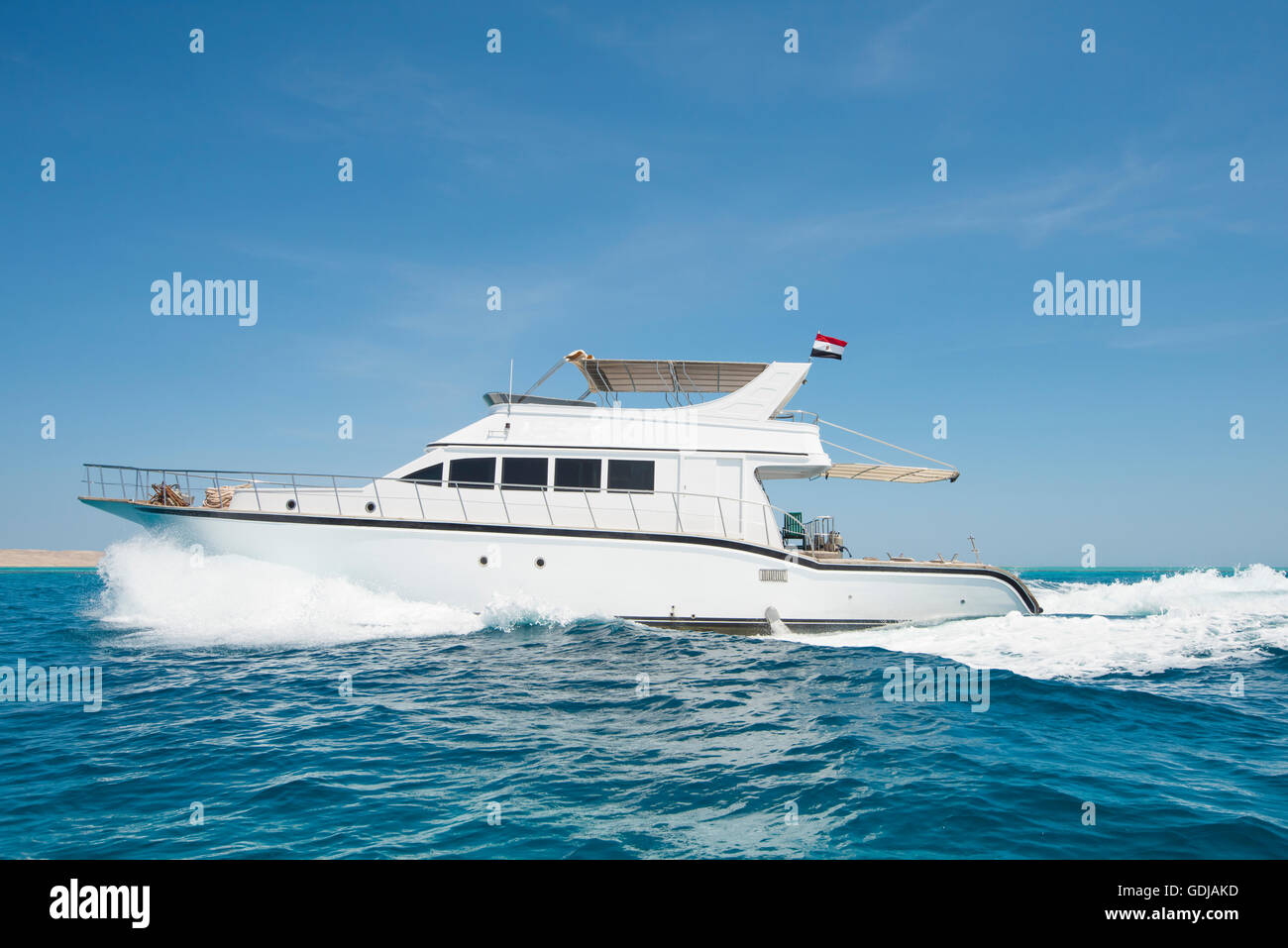 Luxury motor yacht boat sailing under way on tropical ocean with bow ...