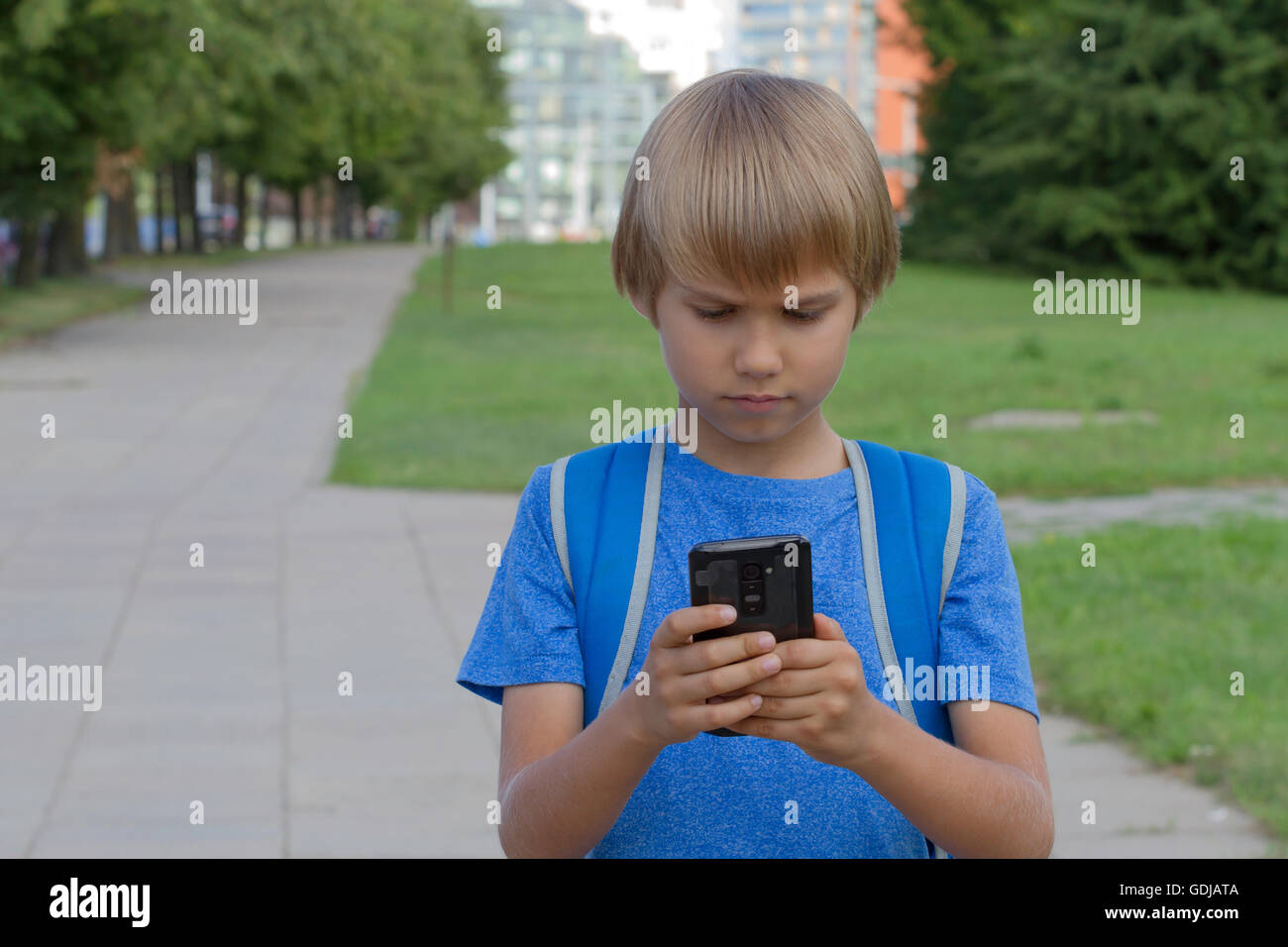 Boy watching application in the mobile phone. Kid go and use ...