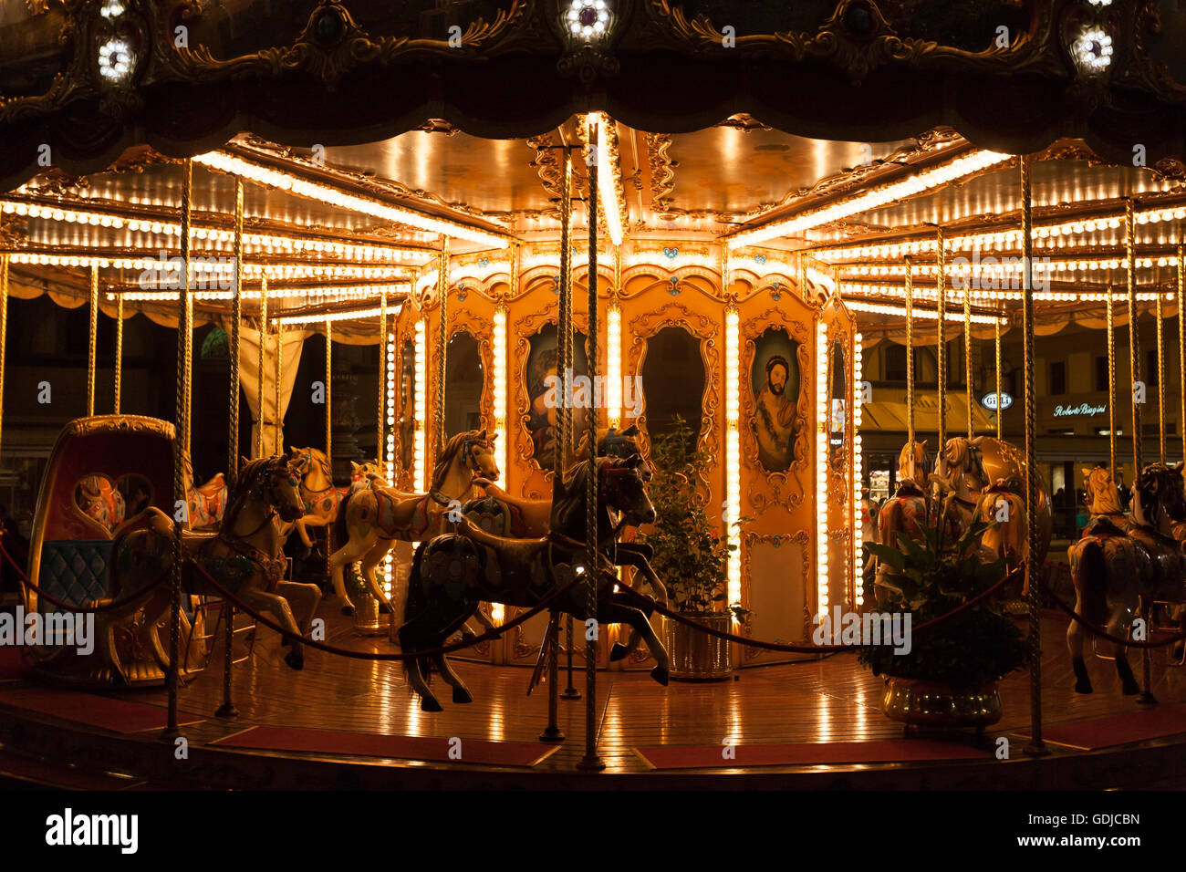 Close up on an old roundabout illuminated by lines of light bulbs Stock ...