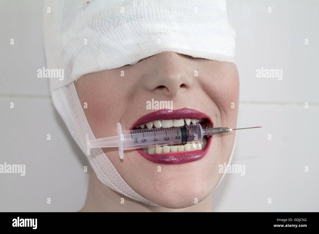 Mental plastic surgery girl eating needle with bandage Stock Photo - Alamy