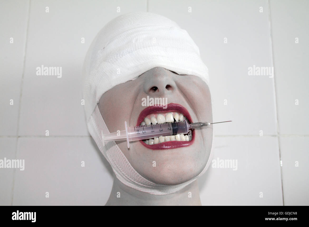 Mental plastic surgery girl eating needle with bandage Stock Photo - Alamy
