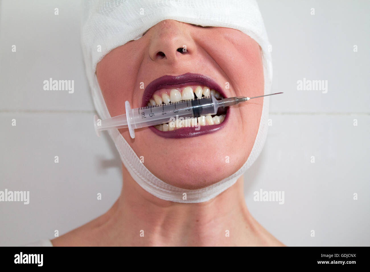Mental plastic surgery girl eating needle with bandage Stock Photo - Alamy