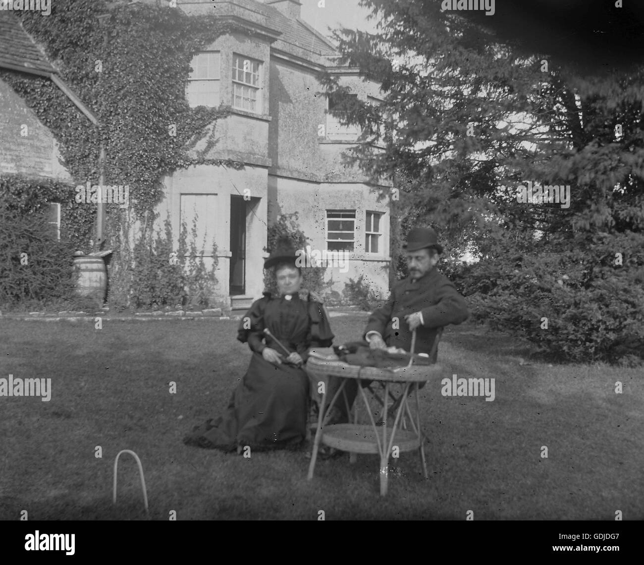 Lady and gent , in Victorian dress, relaxing in a garden c1900 - note ...