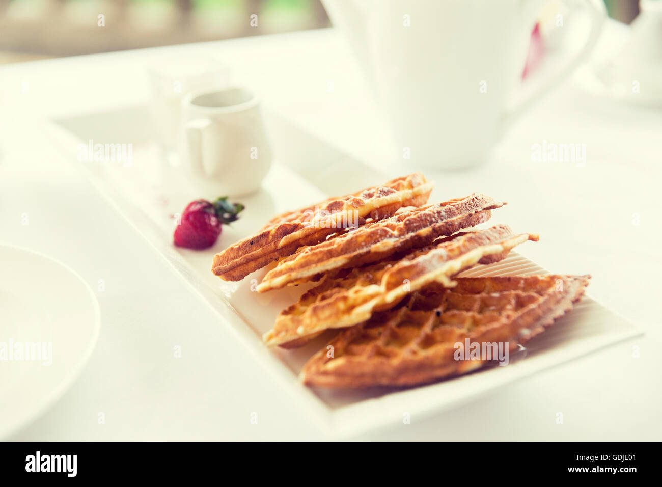 close up of waffles on plate at breakfast table Stock Photo - Alamy