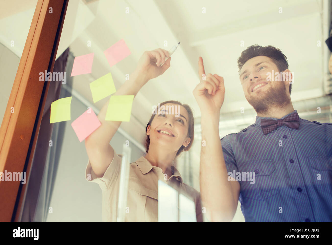 happy creative team writing on blank office glass Stock Photo - Alamy