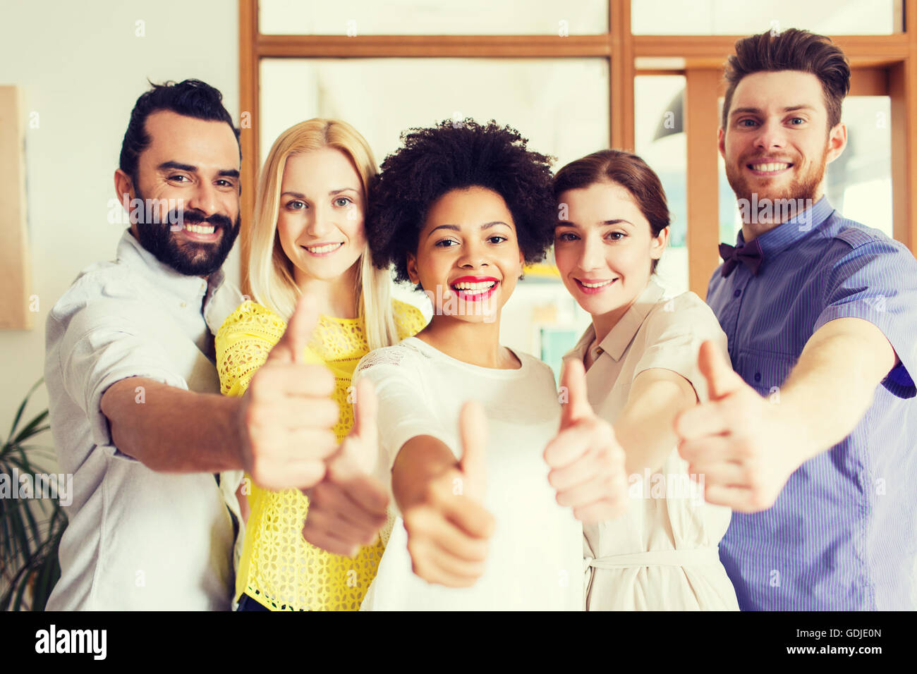 Team creative designers showing thumbs hi-res stock photography and ...