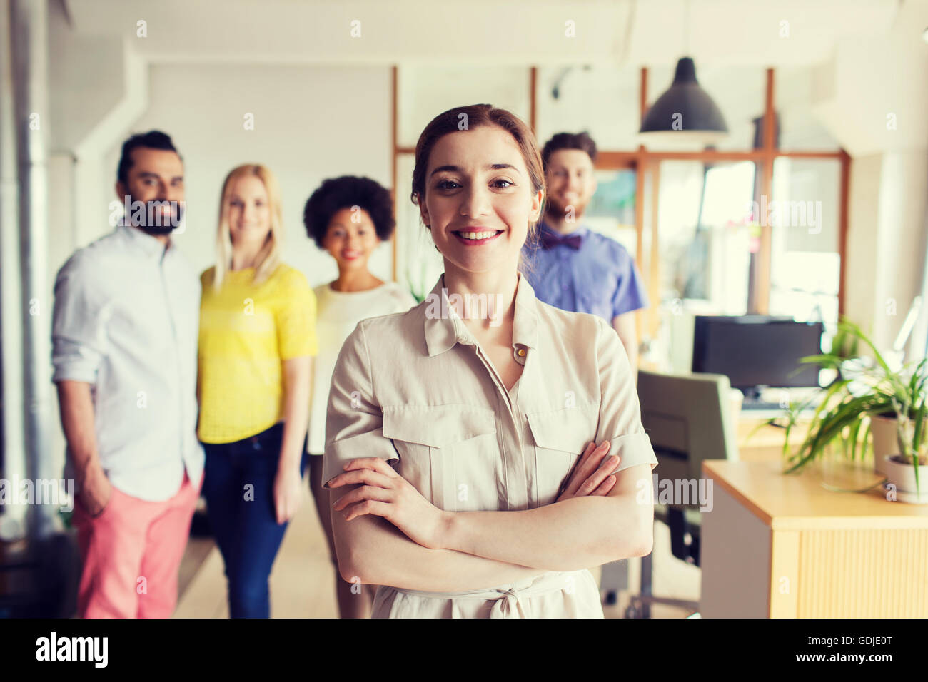 happy young woman over creative team in office Stock Photo - Alamy