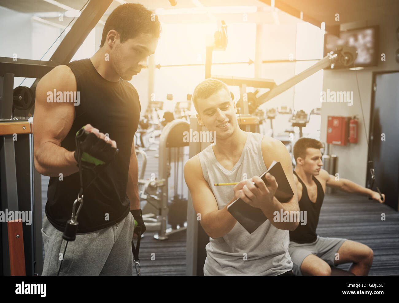 men exercising on gym machine Stock Photo - Alamy
