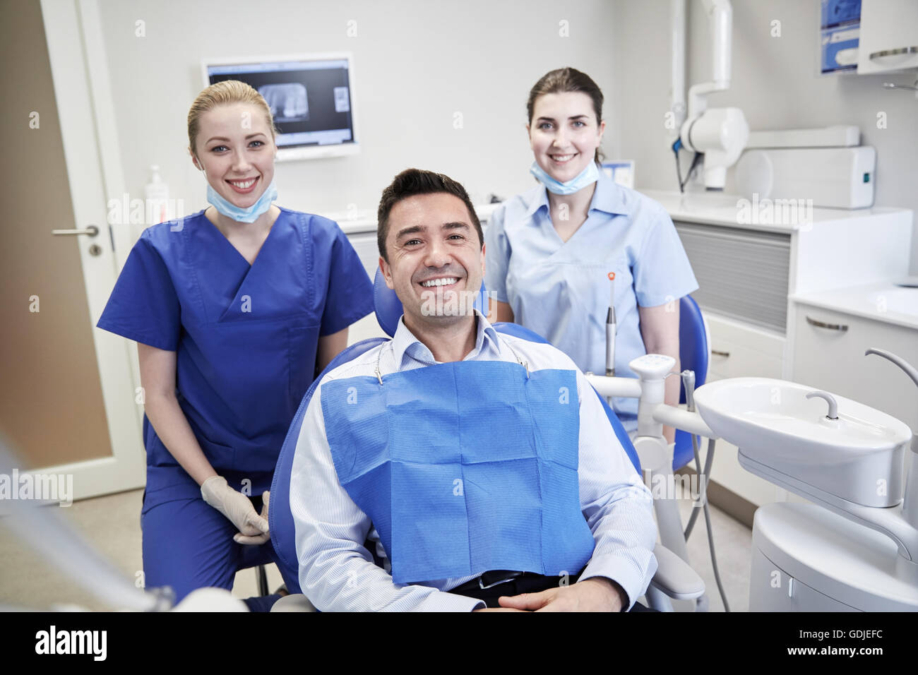 happy female dentists with man patient at clinic Stock Photo - Alamy