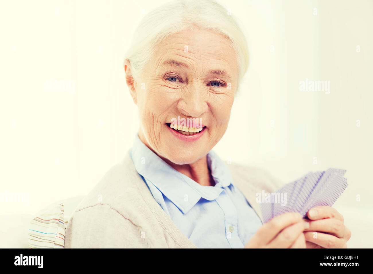 happy senior woman playing cards at home Stock Photo - Alamy