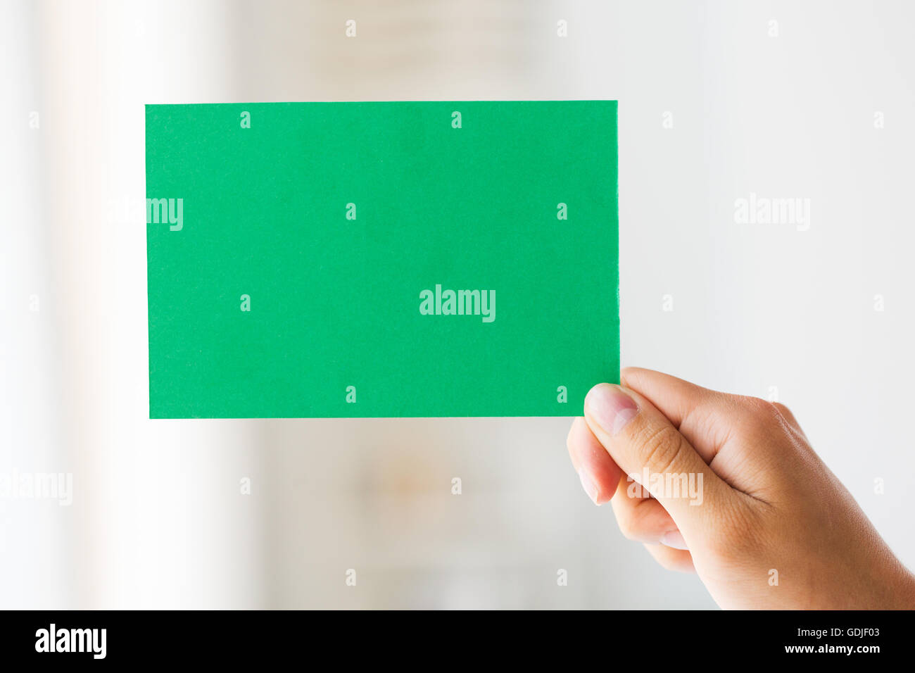 close up of hand holding green paper card Stock Photo - Alamy