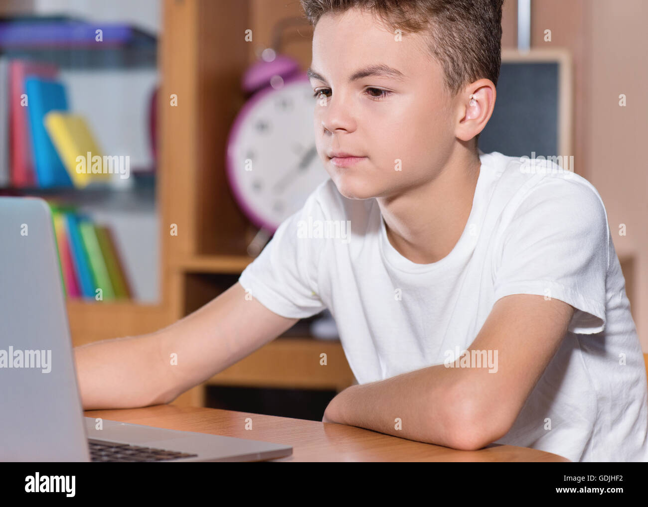 Teen boy working on laptop Stock Photo - Alamy