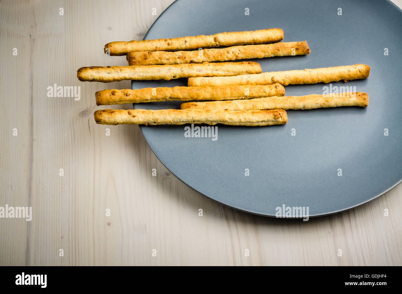 rustic breadsticks in a dish on wood table, close up, background Stock ...