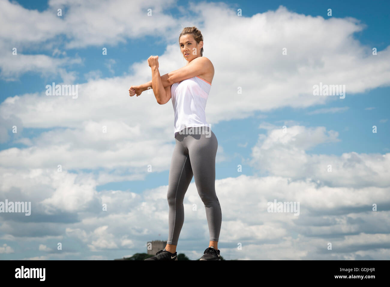 fit blonde woman doing an arm stretch Stock Photo - Alamy