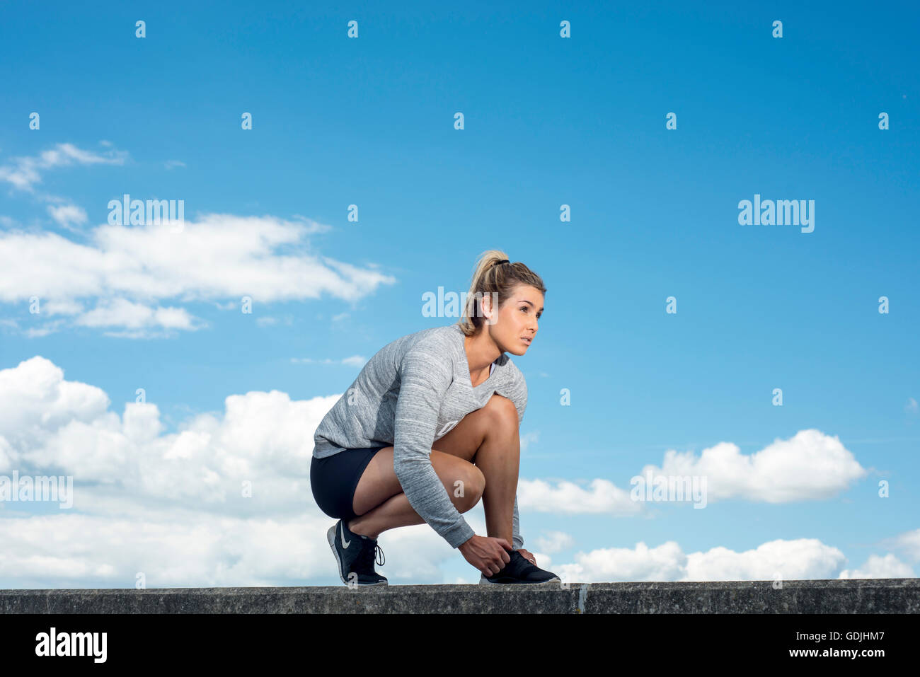 fit woman tying up her shoelaces on her trainers Stock Photo - Alamy
