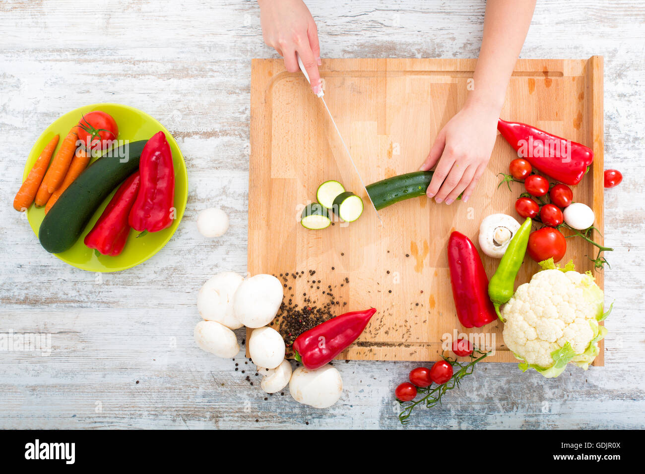 A woman chopping up vegetables at a table Stock Photo - Alamy