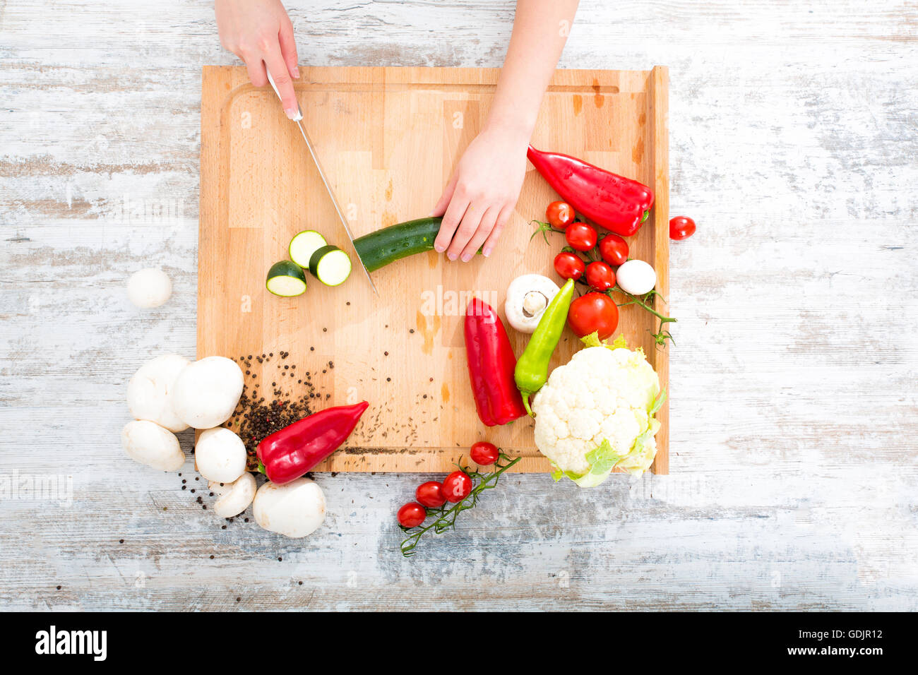 A woman chopping up vegetables at a table Stock Photo - Alamy