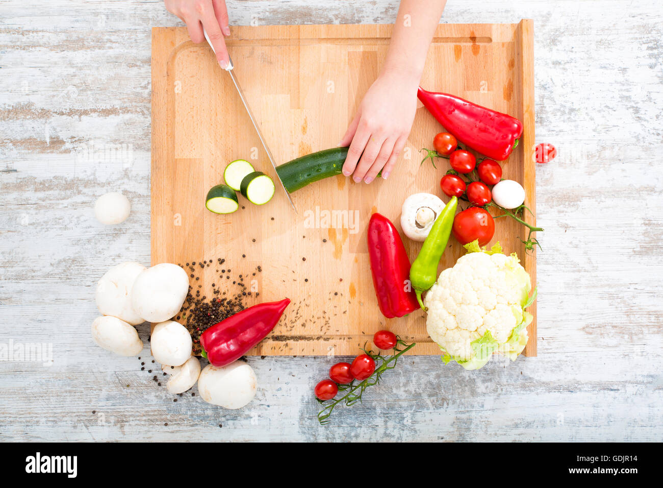A woman chopping up vegetables at a table Stock Photo - Alamy