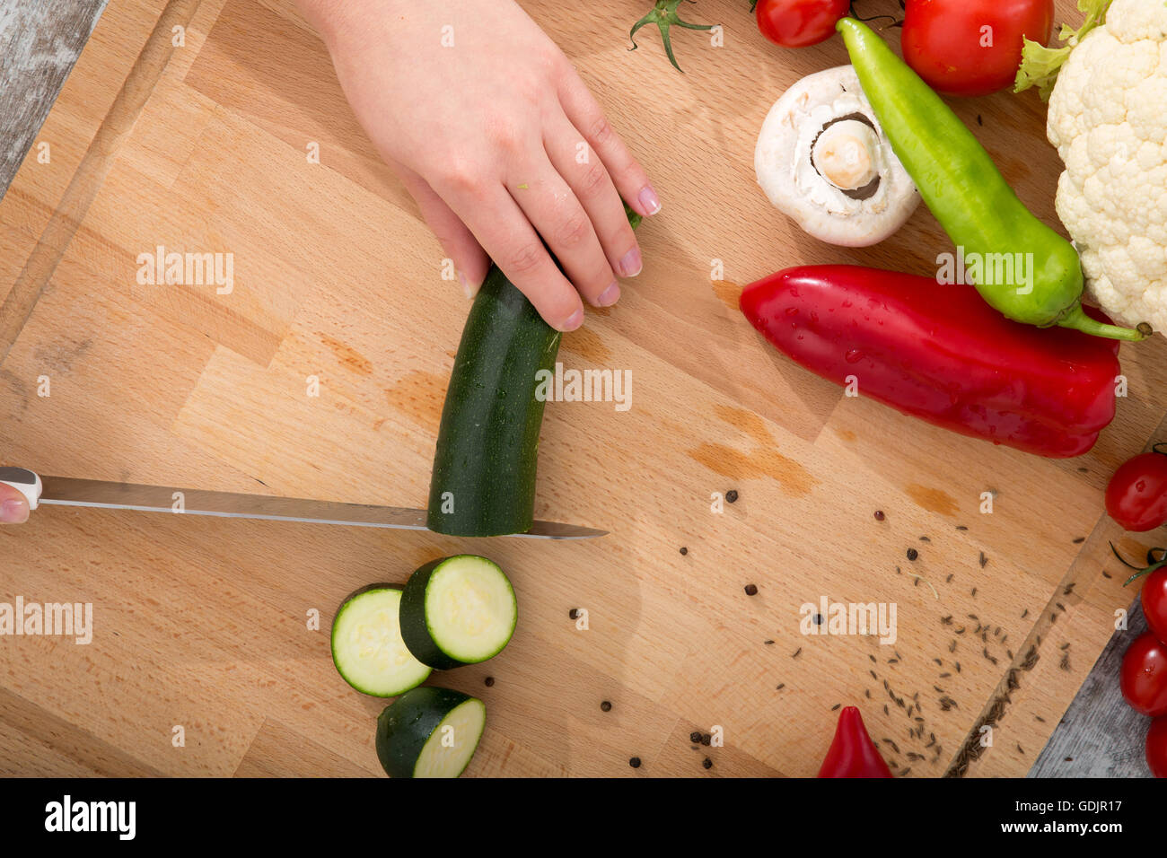 A woman chopping up vegetables at a table Stock Photo - Alamy