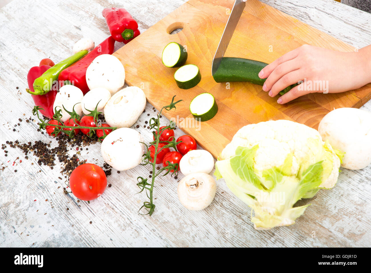 A woman chopping up vegetables at a table Stock Photo - Alamy