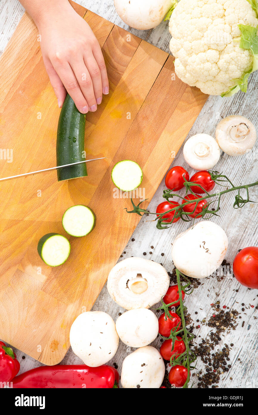A woman chopping up vegetables at a table Stock Photo - Alamy