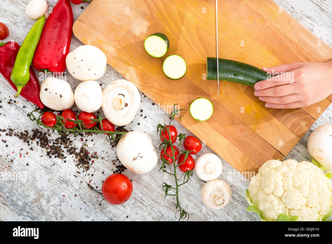 A woman chopping up vegetables at a table Stock Photo - Alamy