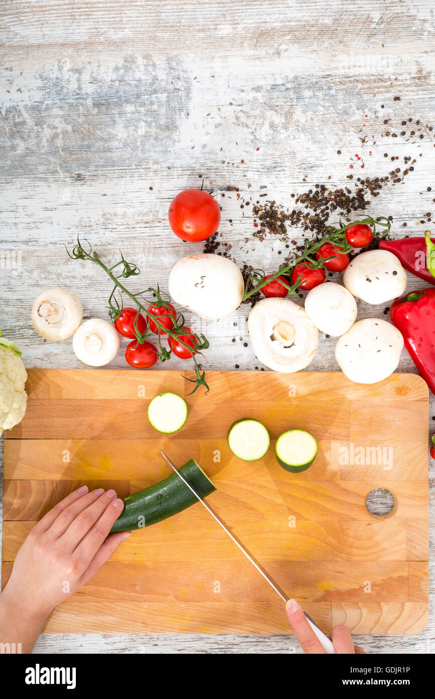 A woman chopping up vegetables at a table Stock Photo - Alamy