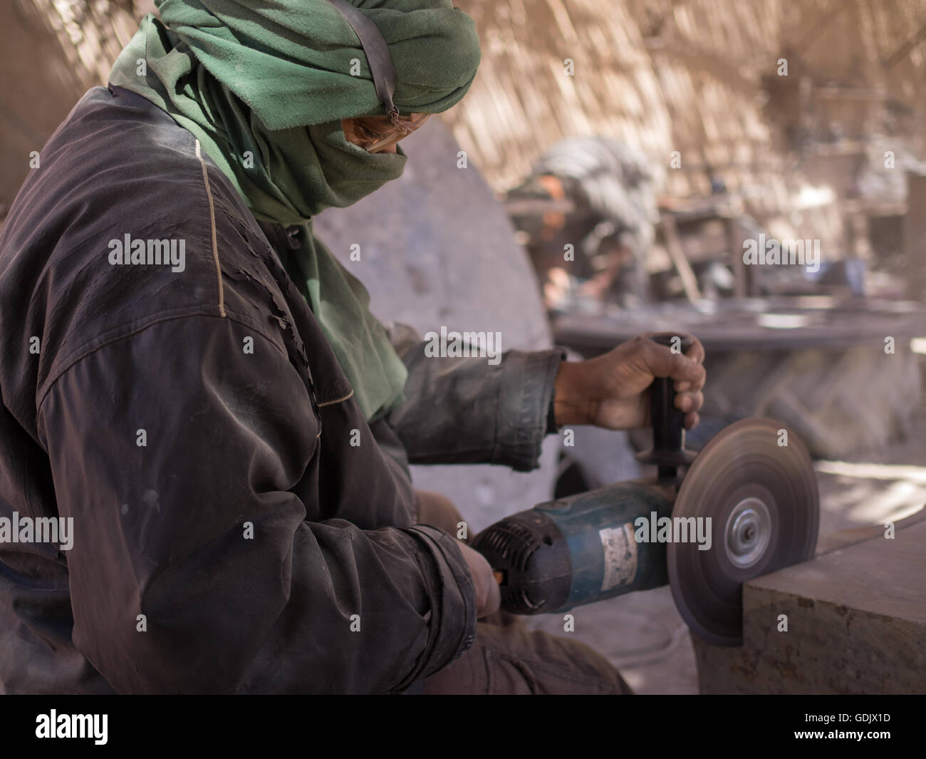 Man grinding fossilized creatures, Morocco Stock Photo - Alamy