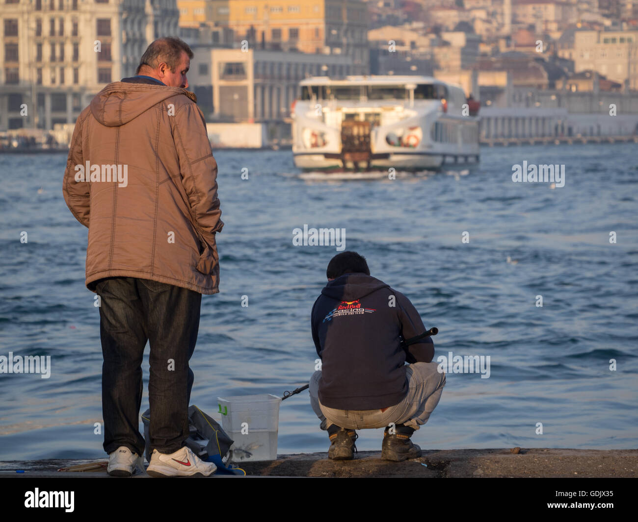 Rear view of men fishing in Istanbul, Turkey Stock Photo - Alamy